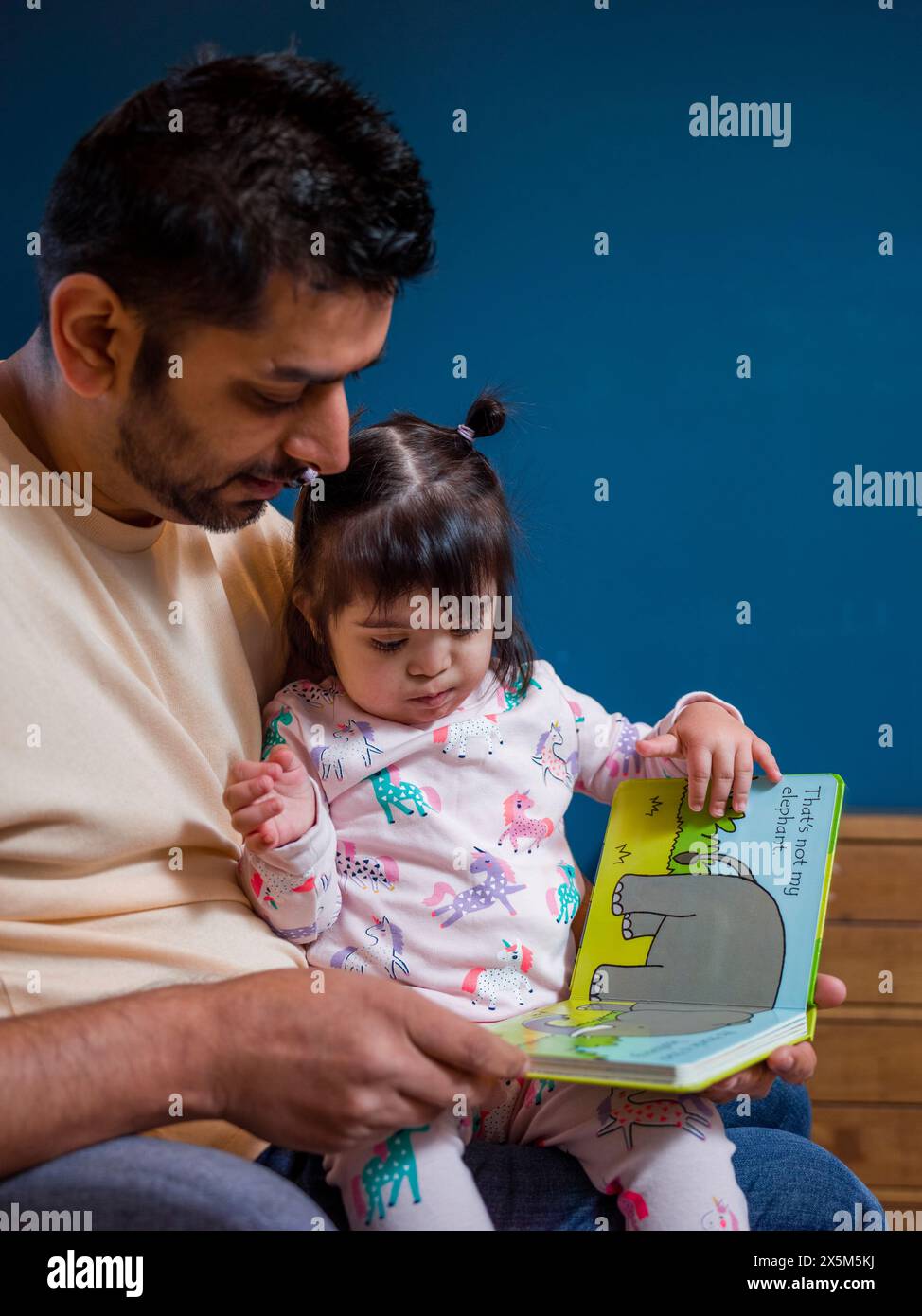 Father reading book to daughter Stock Photo - Alamy