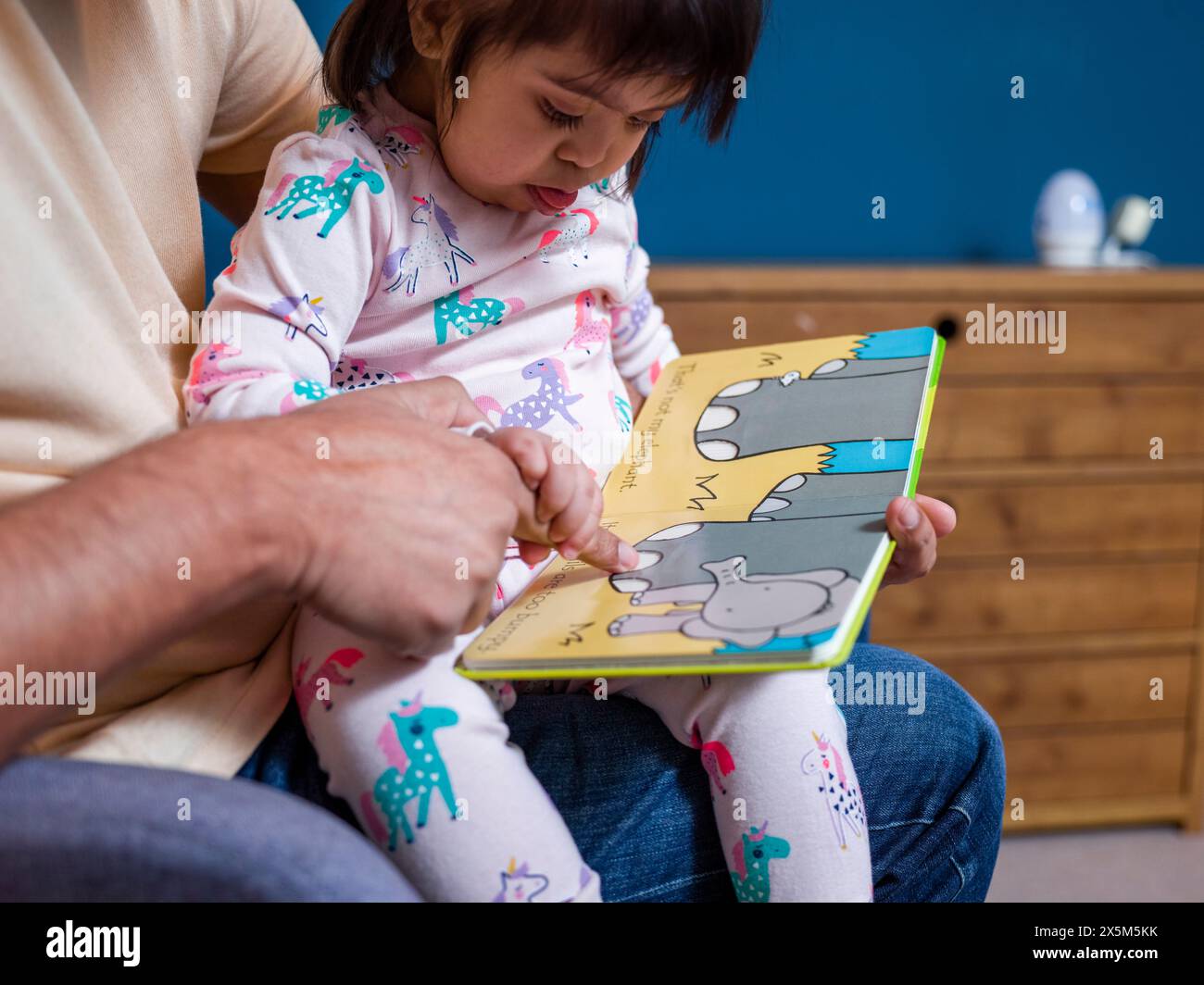 Father reading book to daughter Stock Photo - Alamy