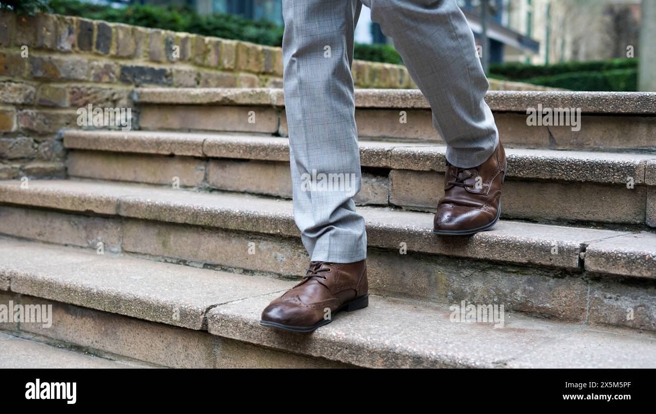 Business man walking down stairs, low section Stock Photo - Alamy