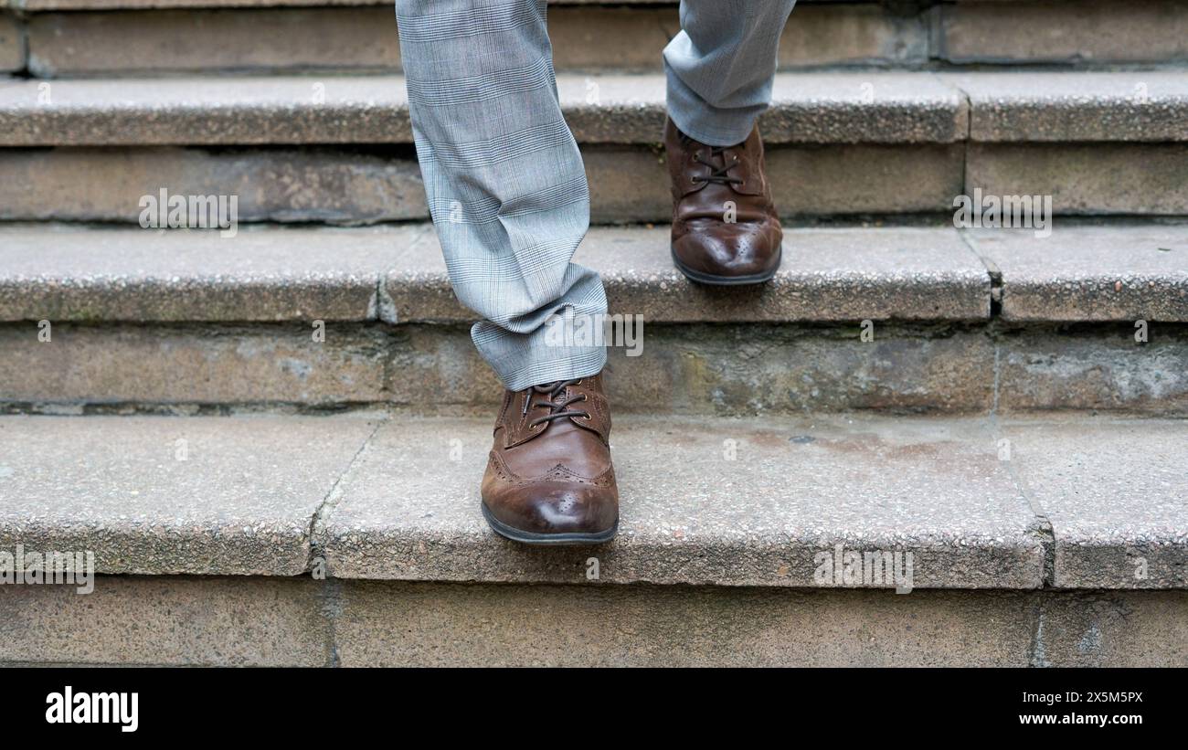 Business man walking down stairs, low section Stock Photo - Alamy
