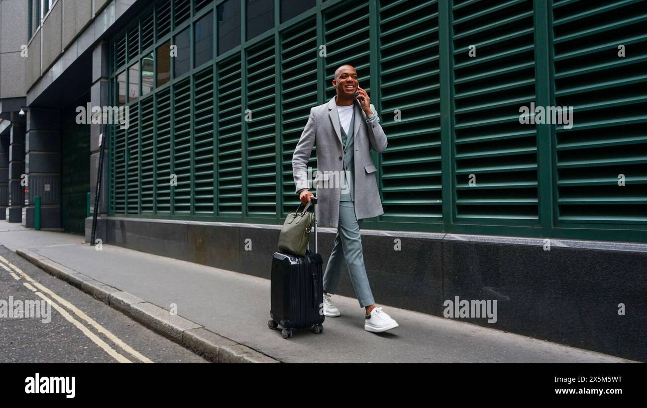 Business man pulling suitcase Stock Photo - Alamy
