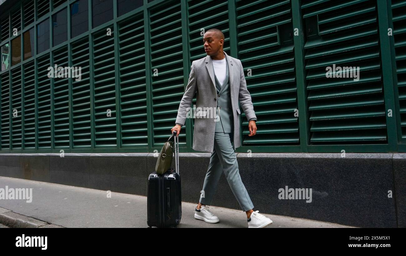 Business man pulling suitcase Stock Photo - Alamy