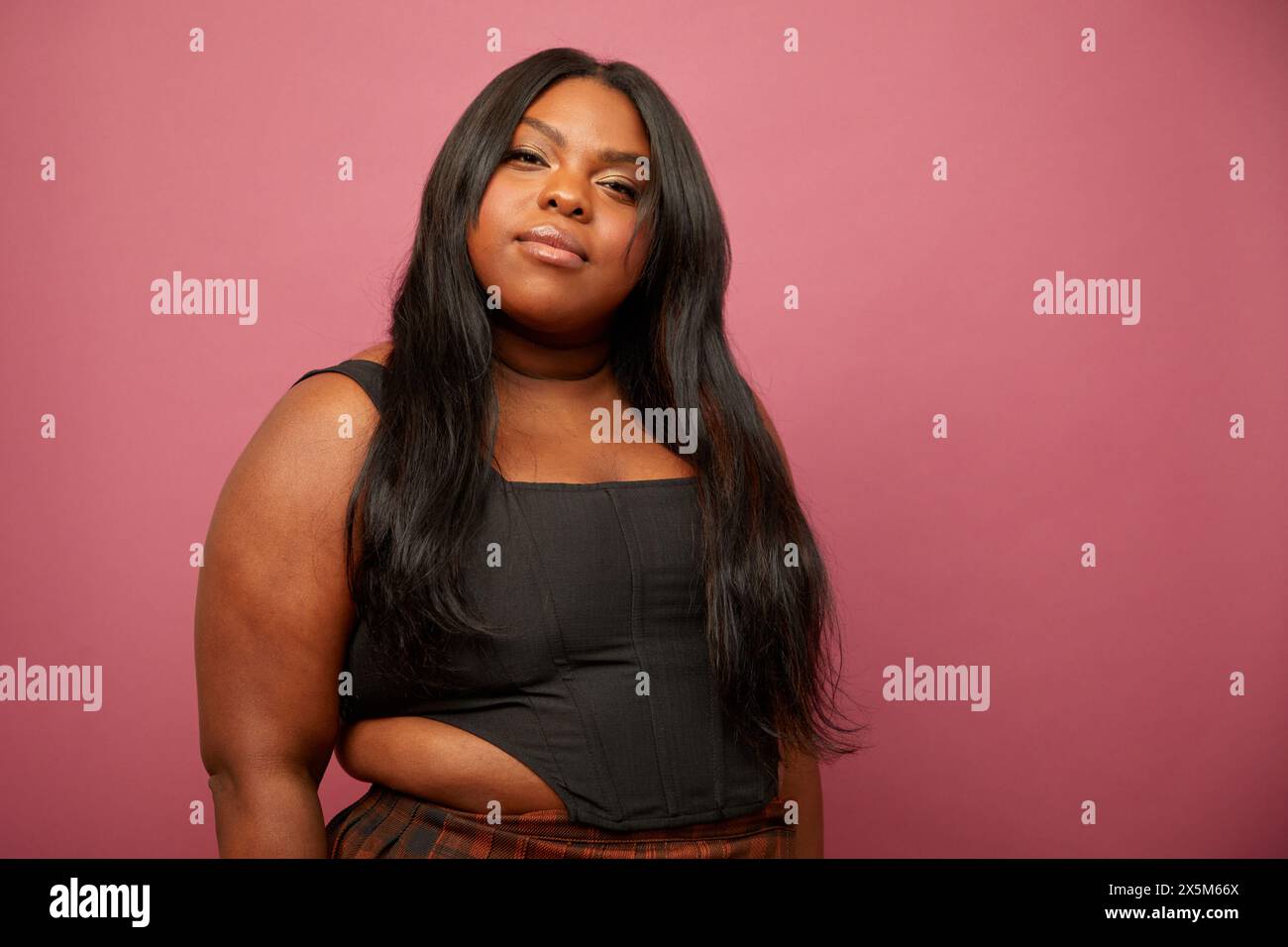 Studio portrait of plus size woman against pink background Stock Photo ...