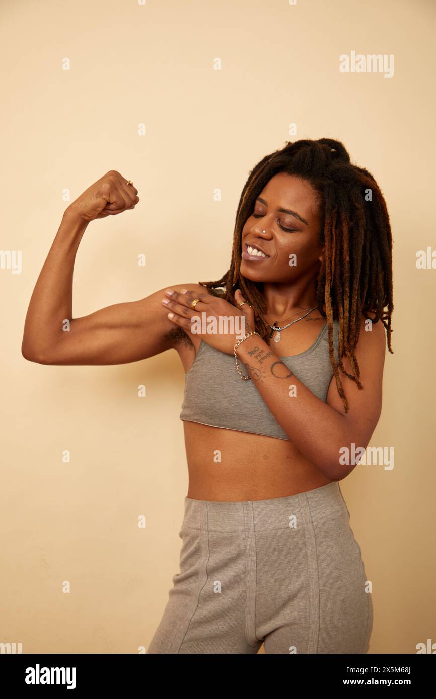 Studio shot of woman with dreadlocks flexing muscles Stock Photo - Alamy