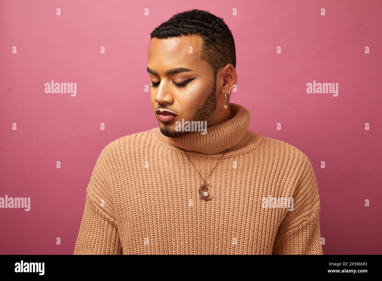 Studio portrait of queer man against purple background Stock Photo - Alamy