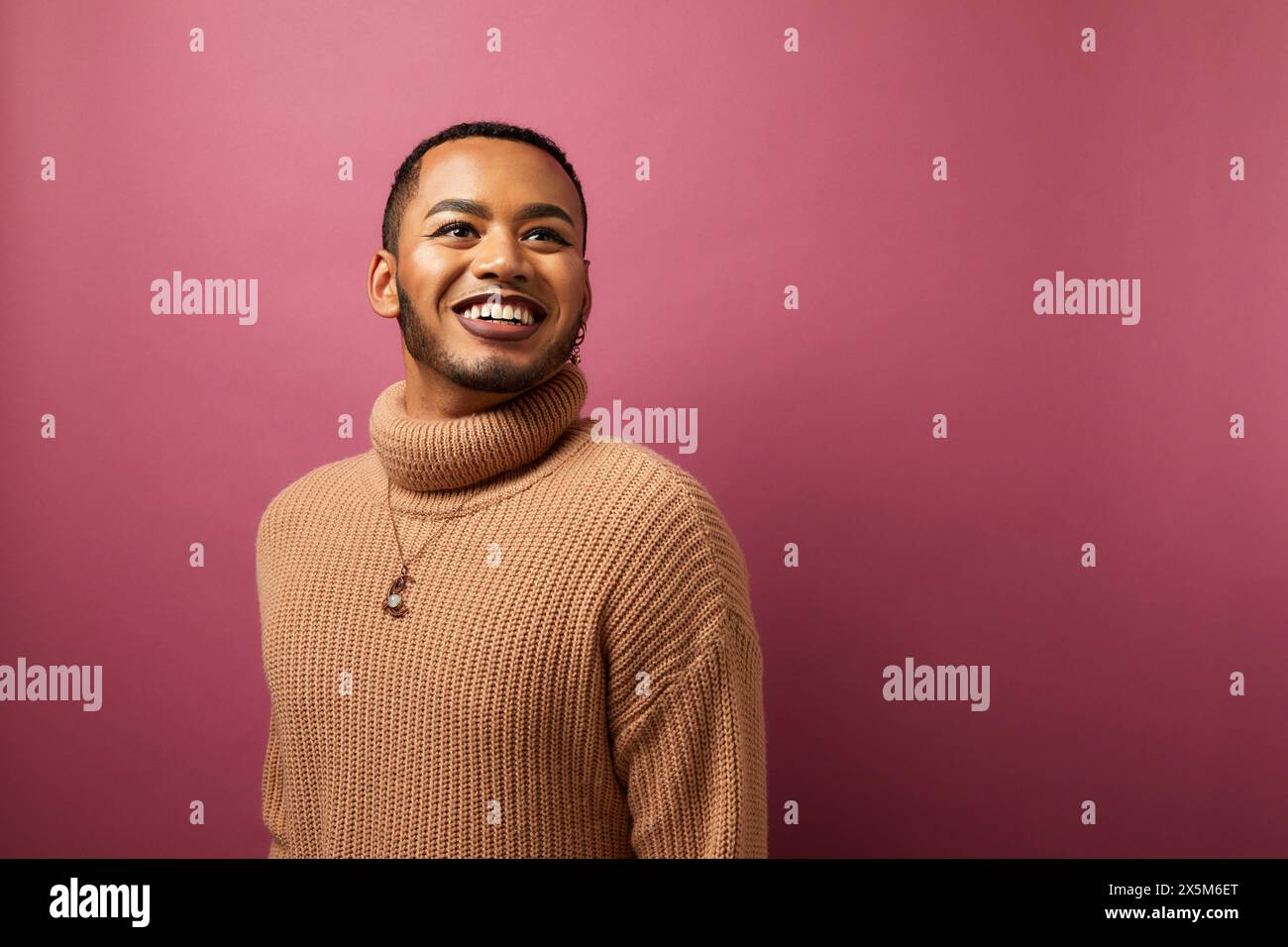 Studio portrait of queer man against purple background Stock Photo - Alamy