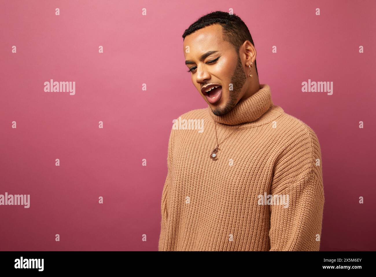Studio portrait of queer man against purple background Stock Photo - Alamy