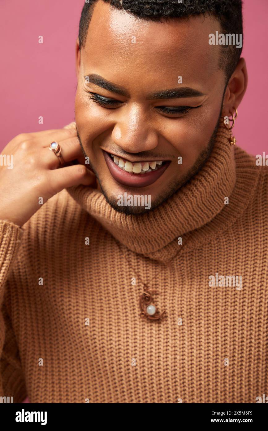 Close-up of queer man against purple background Stock Photo - Alamy