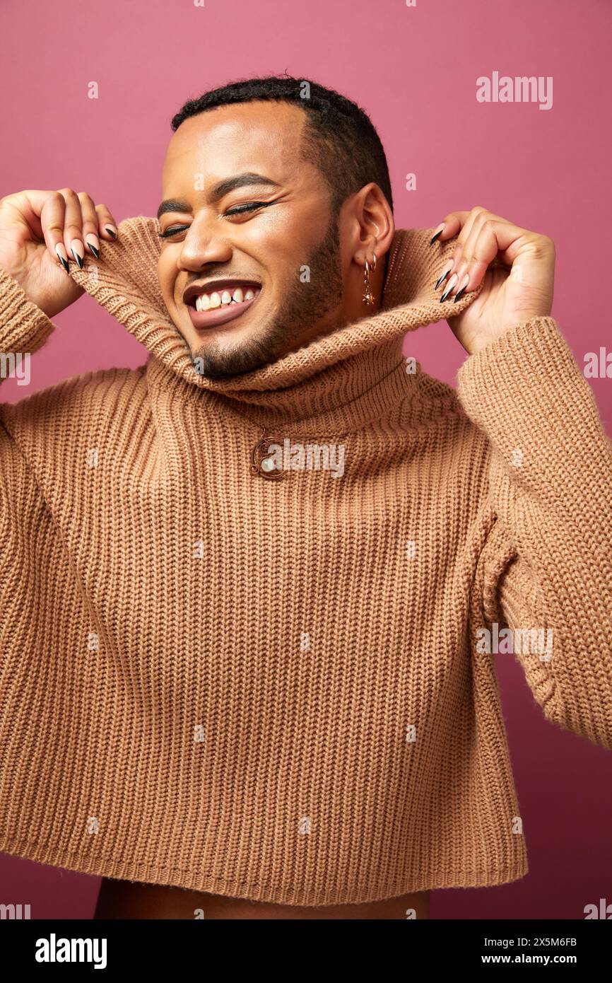 Studio portrait of queer man laughing against purple background Stock ...