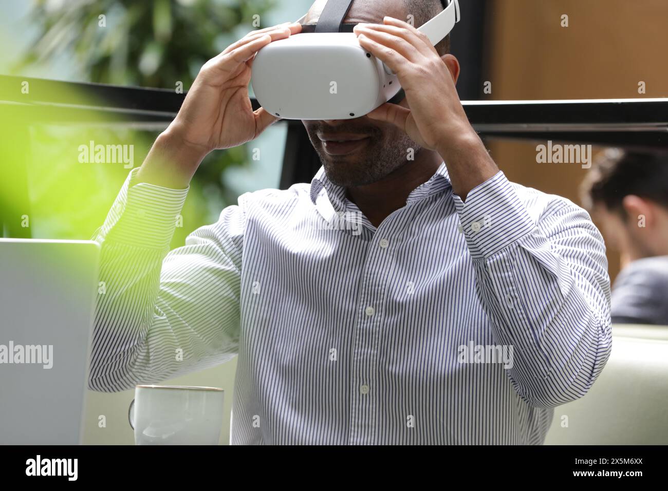 Businessman putting on virtual reality headset Stock Photo - Alamy