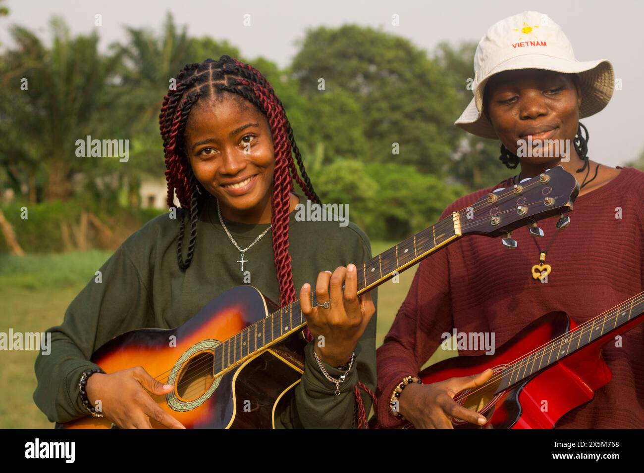 Two young women playing guitars Stock Photo - Alamy