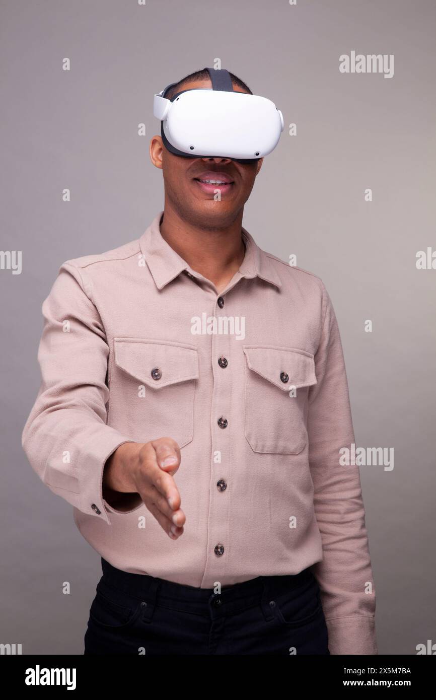 Man in virtual reality headset making handshake gesture Stock Photo - Alamy