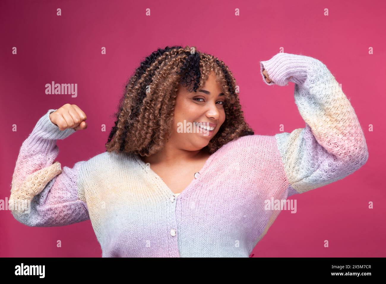 Portrait of smiling woman flexing bicep Stock Photo - Alamy