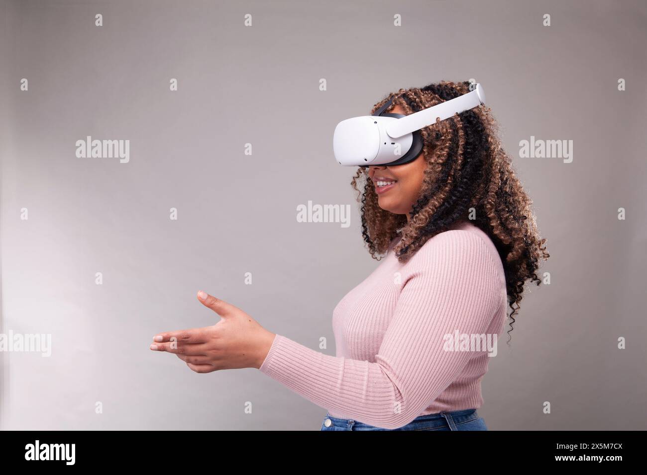 Woman wearing virtual reality headset and making handshake gesture ...