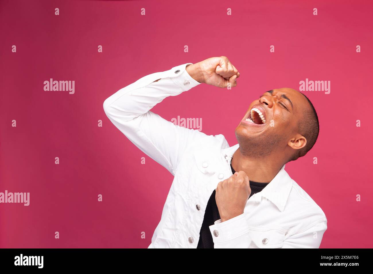 Smiling man punching air and celebrating Stock Photo - Alamy