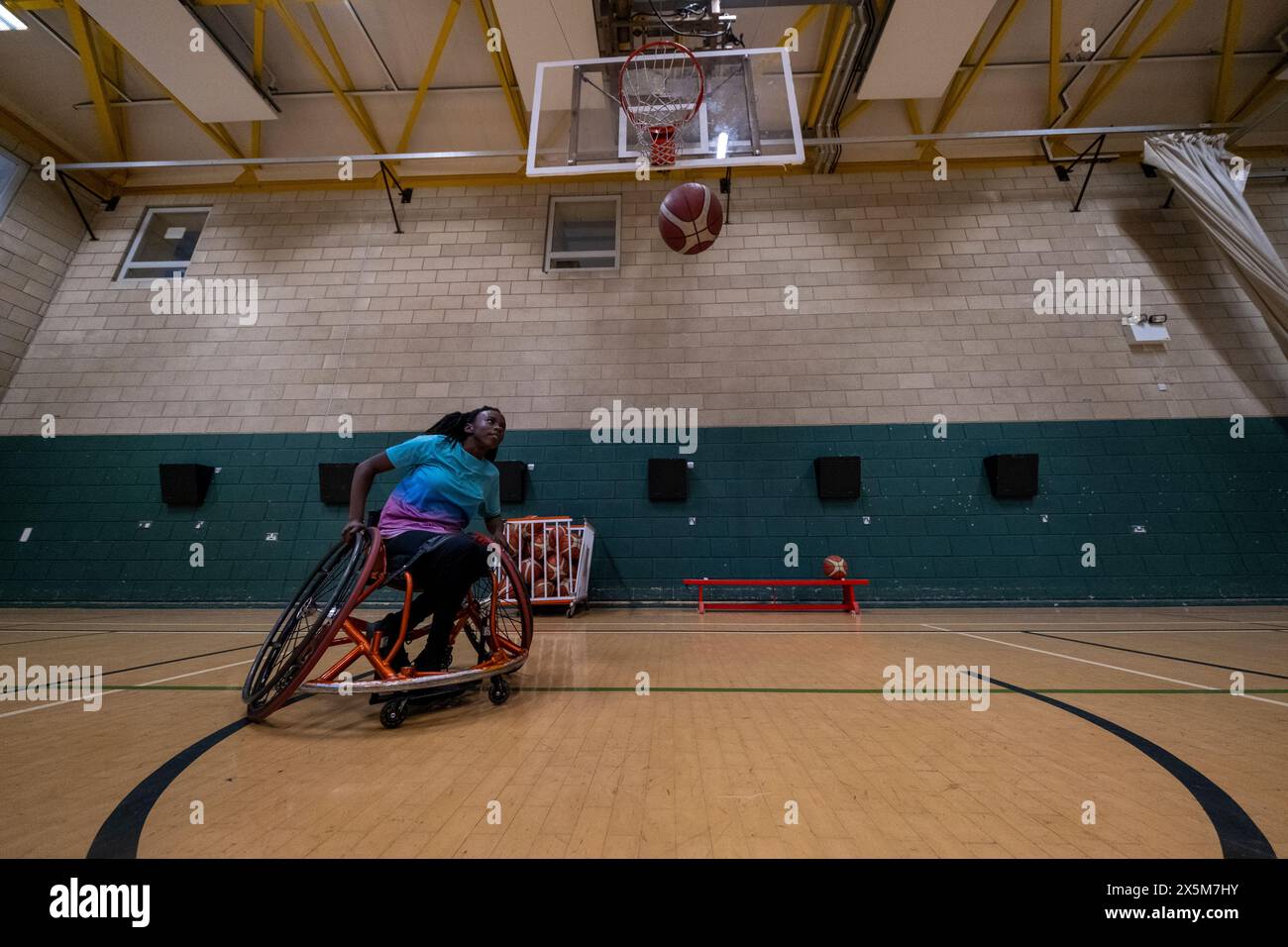 Teenage girl in wheelchair practicing basketball Stock Photo - Alamy