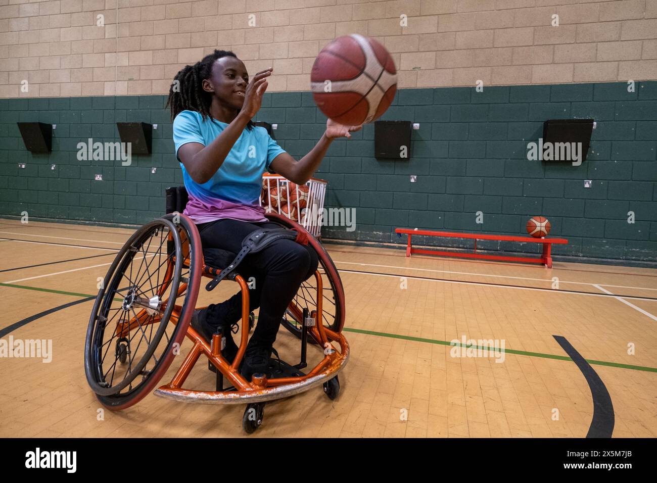 Teenage girl in wheelchair practicing basketball Stock Photo - Alamy