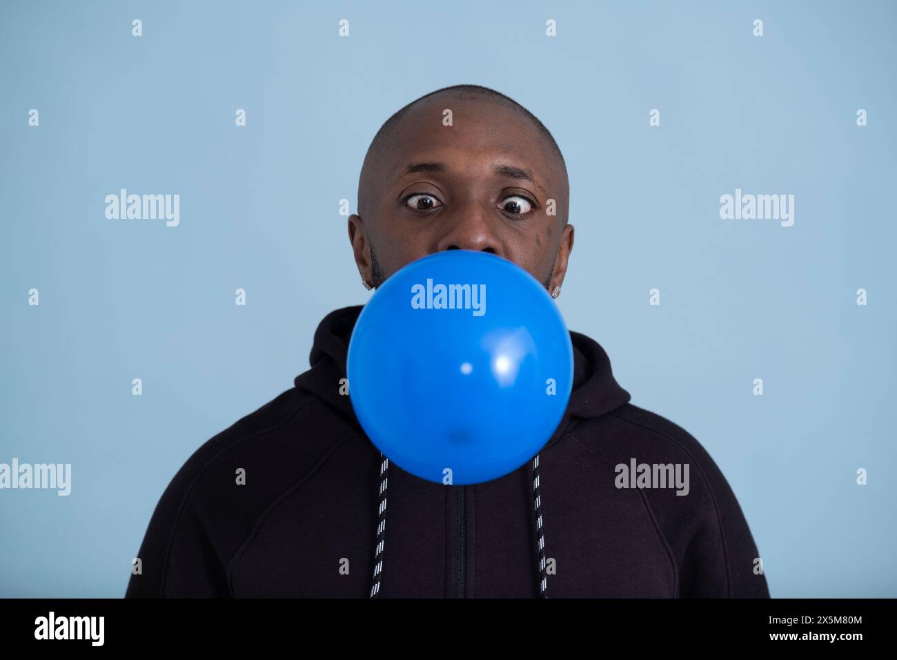 Studio portrait of mid adult man chewing gum and blowing bubble Stock ...