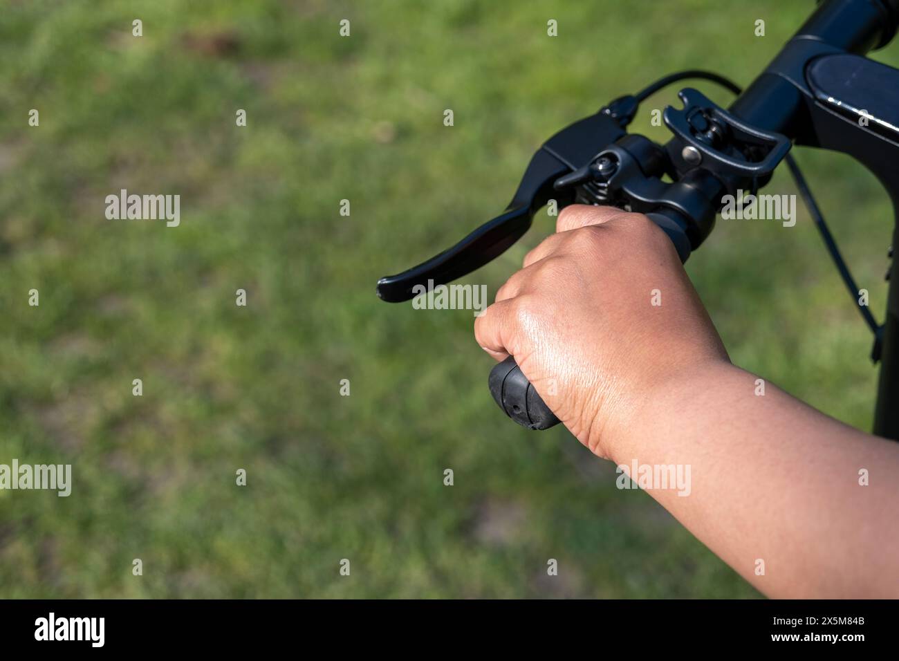 Hand of girl holding bicycle handle Stock Photo - Alamy