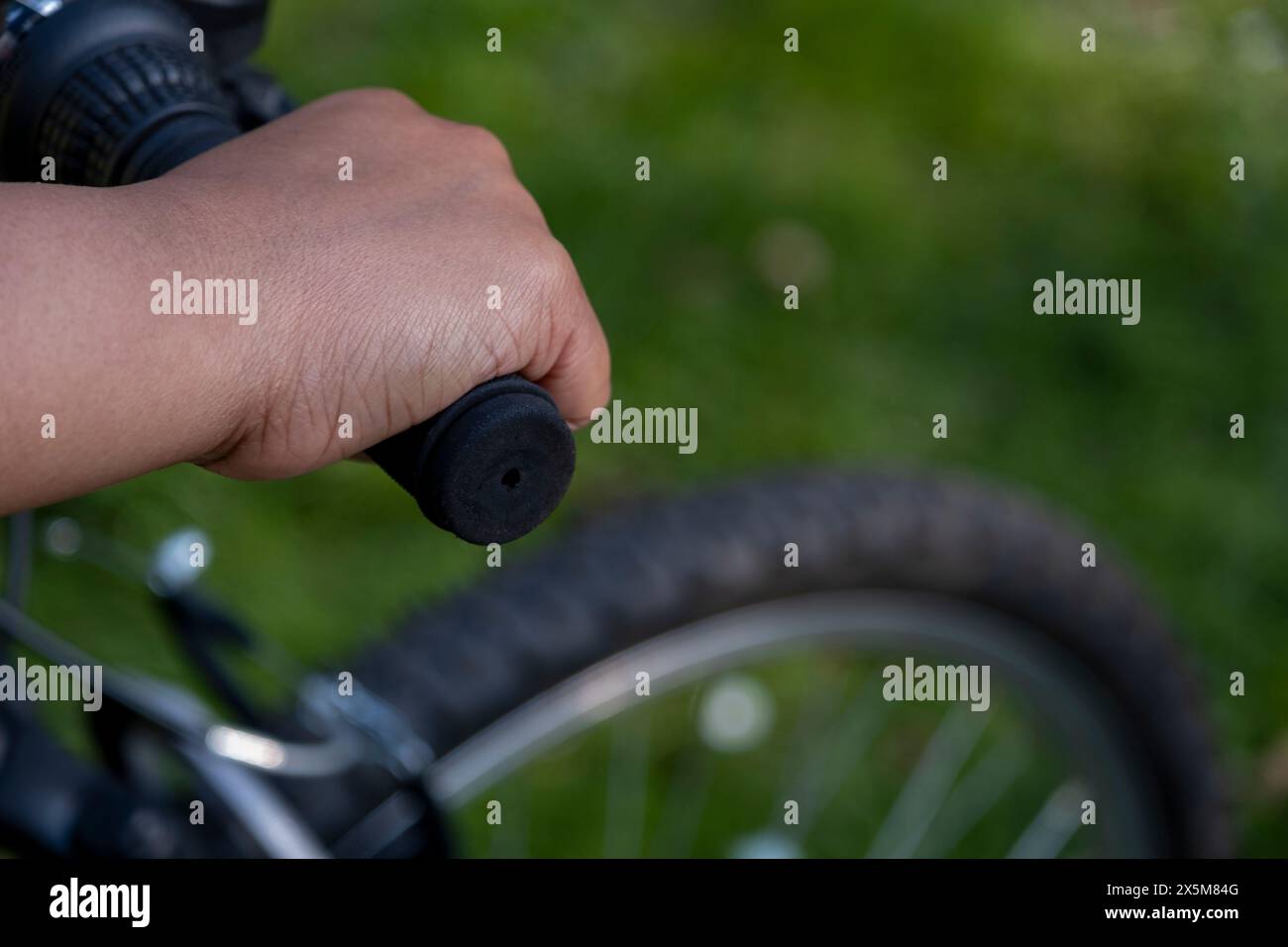 Hand of girl holding bicycle handle Stock Photo - Alamy