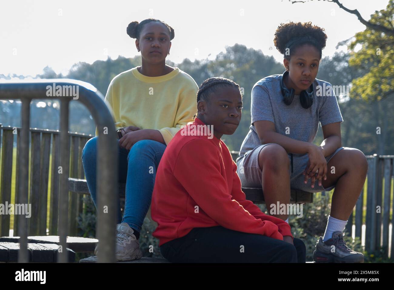 Friends sitting on bench Stock Photo - Alamy