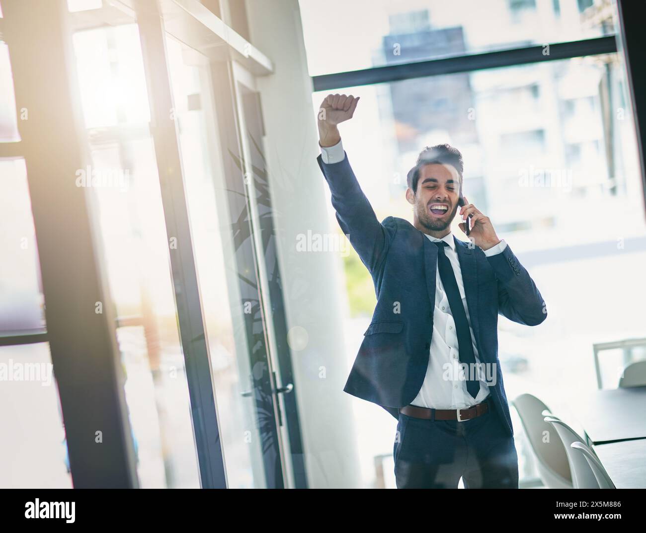 Excited businessman, fist pump and winning with phone call for ...