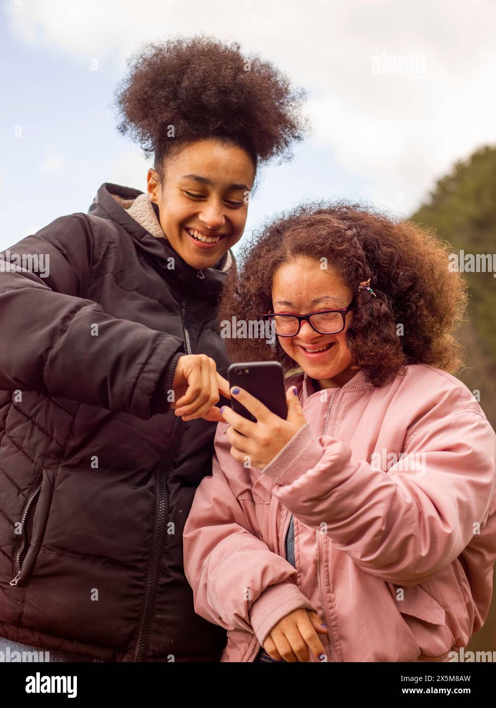 Two girls with mobile phone Stock Photo - Alamy