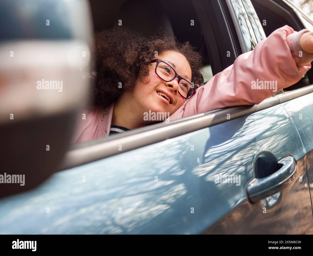 Girl leaning out of car window Stock Photo - Alamy