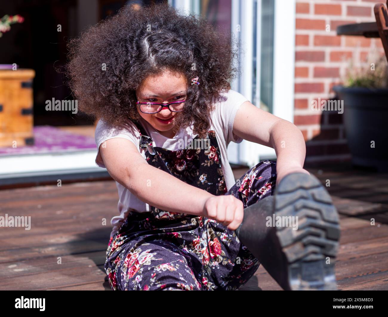 Girl putting on rubber boots Stock Photo - Alamy