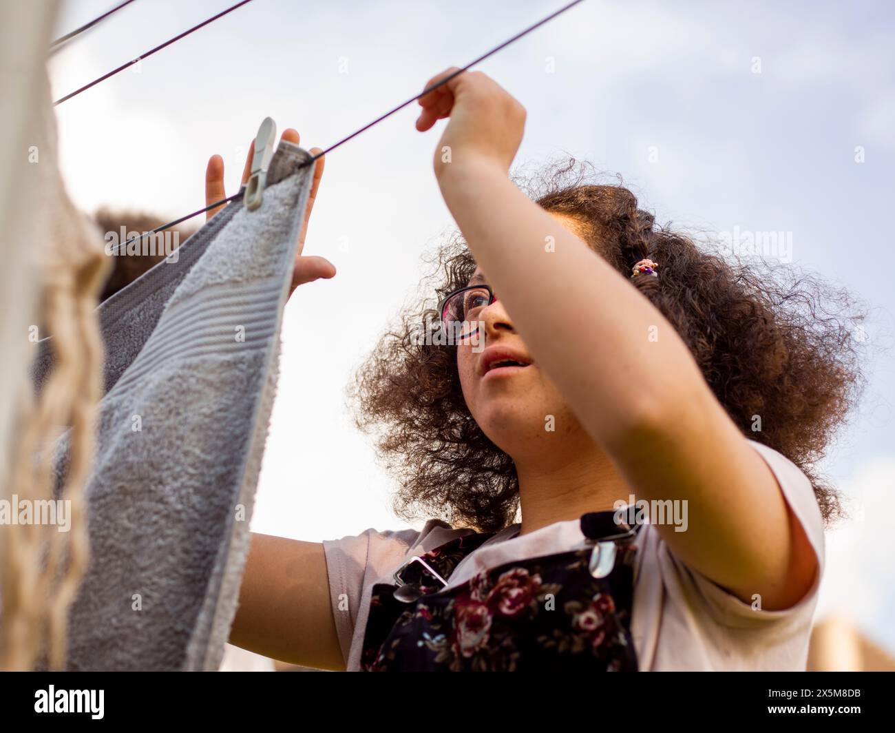 Girl hanging laundry in backyard Stock Photo - Alamy