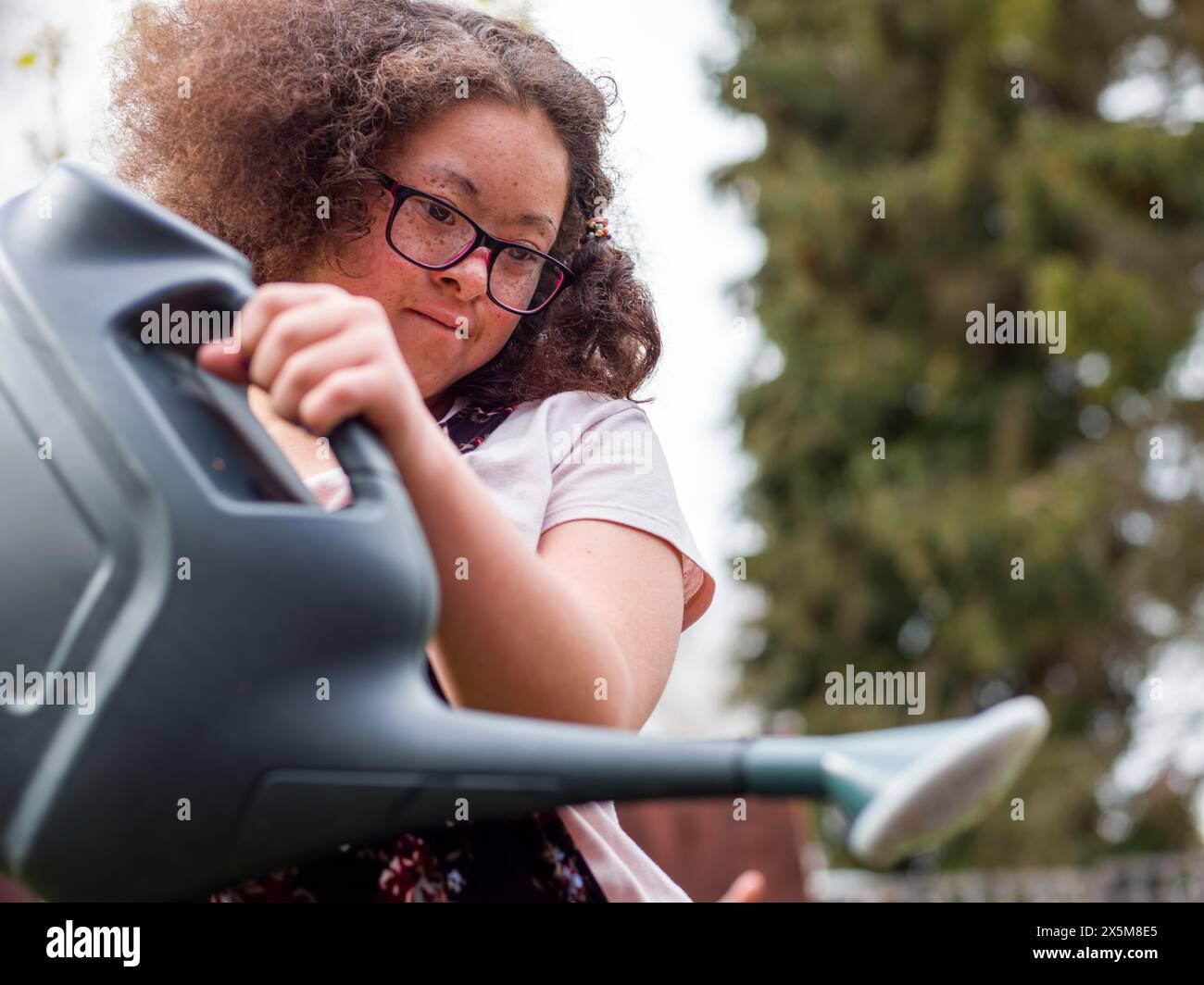 Girl using watering can Stock Photo - Alamy