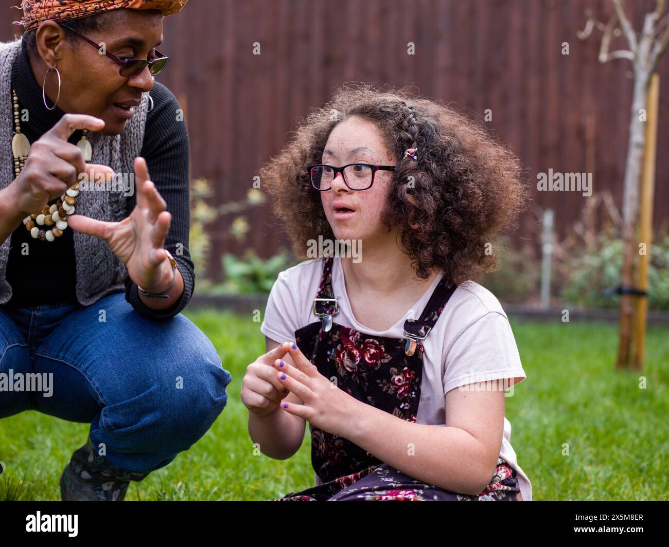 Mother and daughter talking in backyard Stock Photo - Alamy