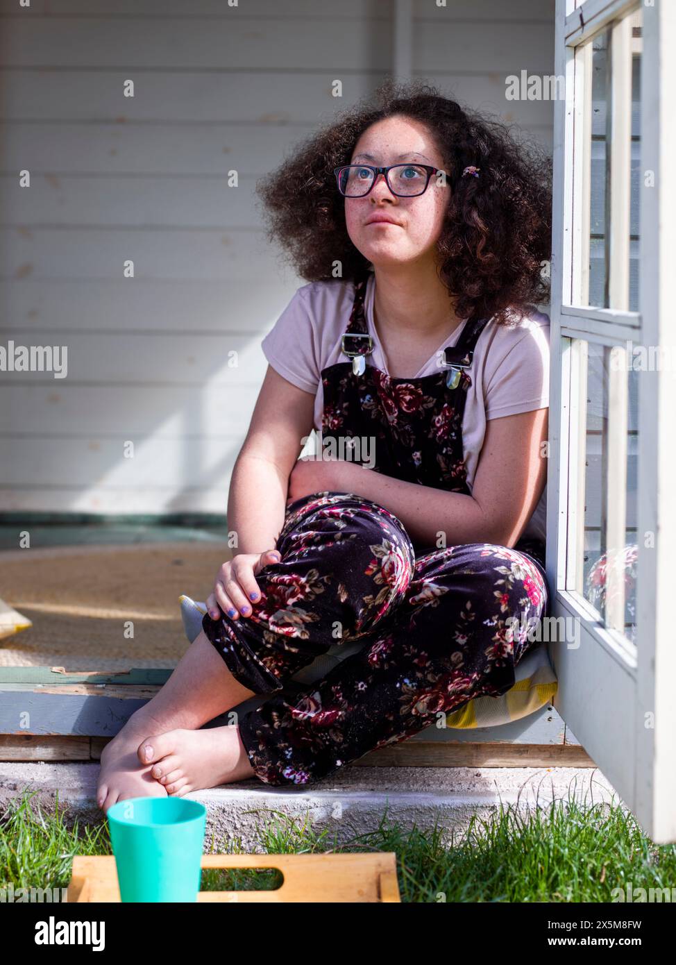 Girl sitting on porch Stock Photo - Alamy