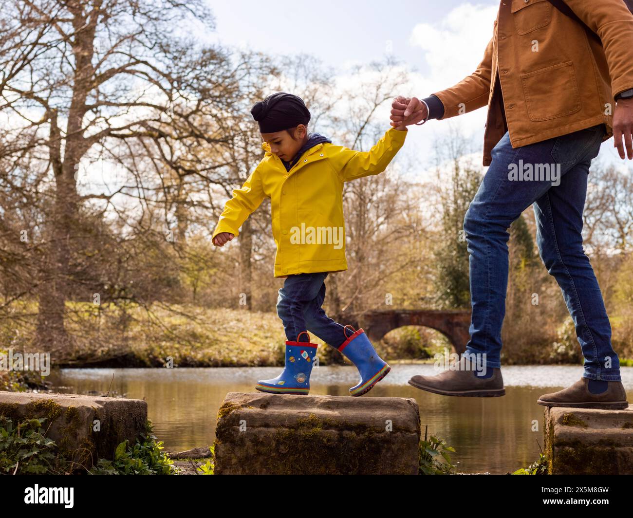Father with son on stepping stones on lake Stock Photo - Alamy