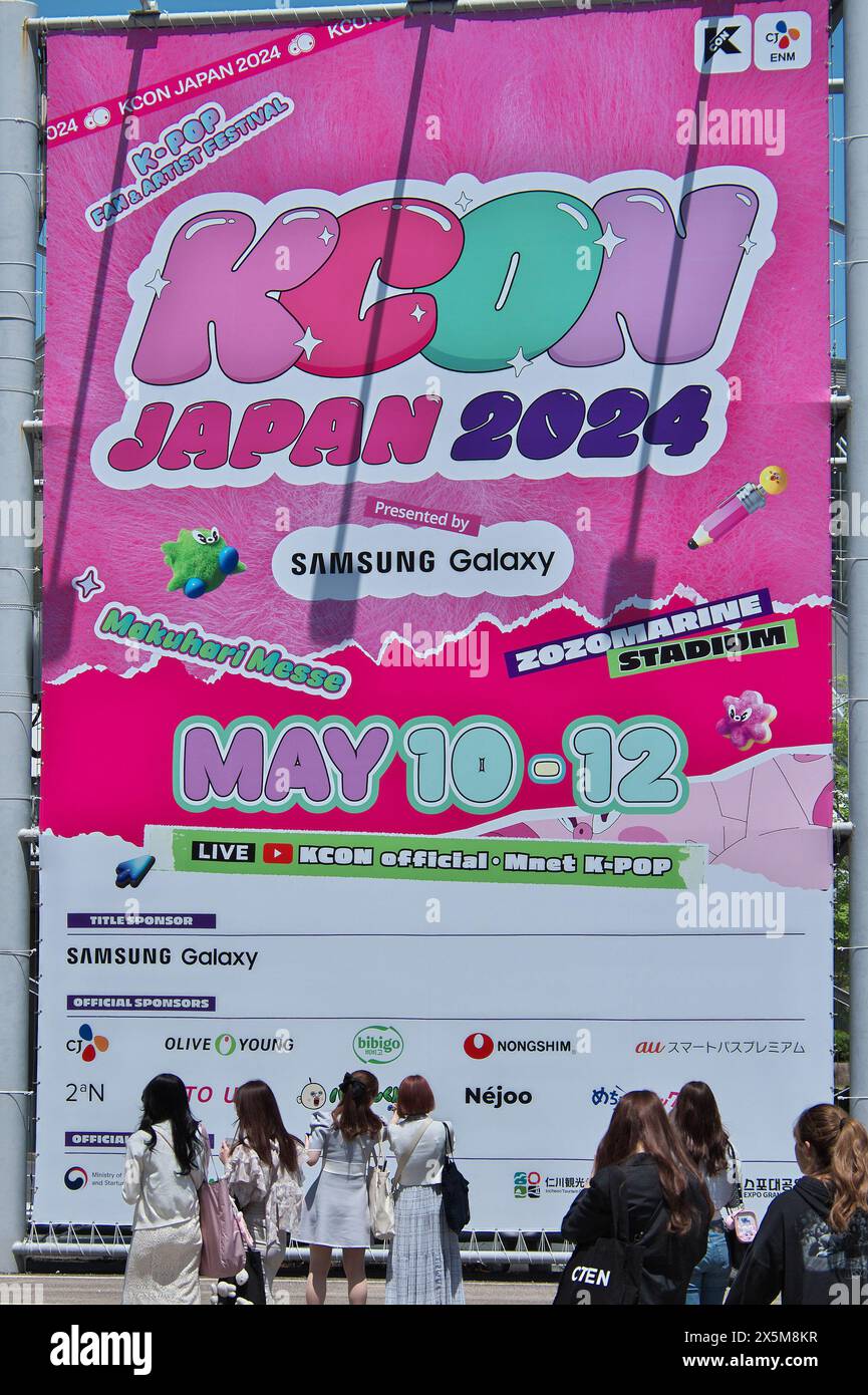 People take photos of a banner outside of the venue at KCON, Japan ...