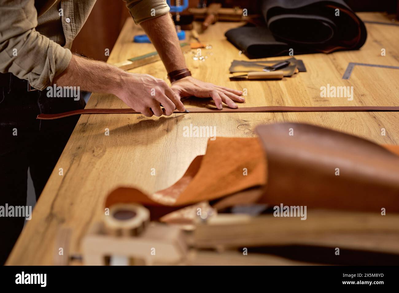 skilled artisan Burnishing the Short Edges of belt, close up cropped ...