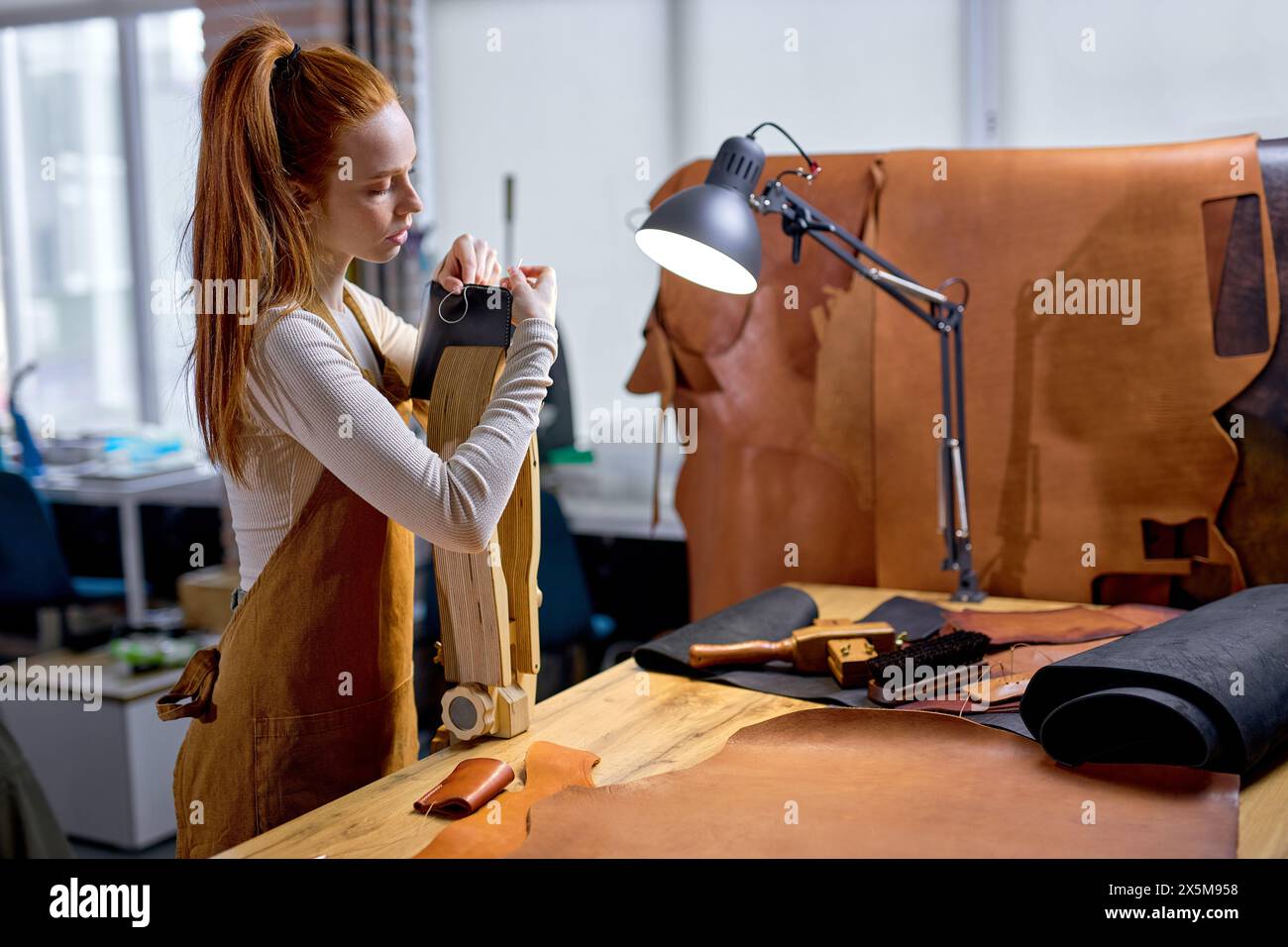 professional female artisan working on Leather Stitching Clam side view ...