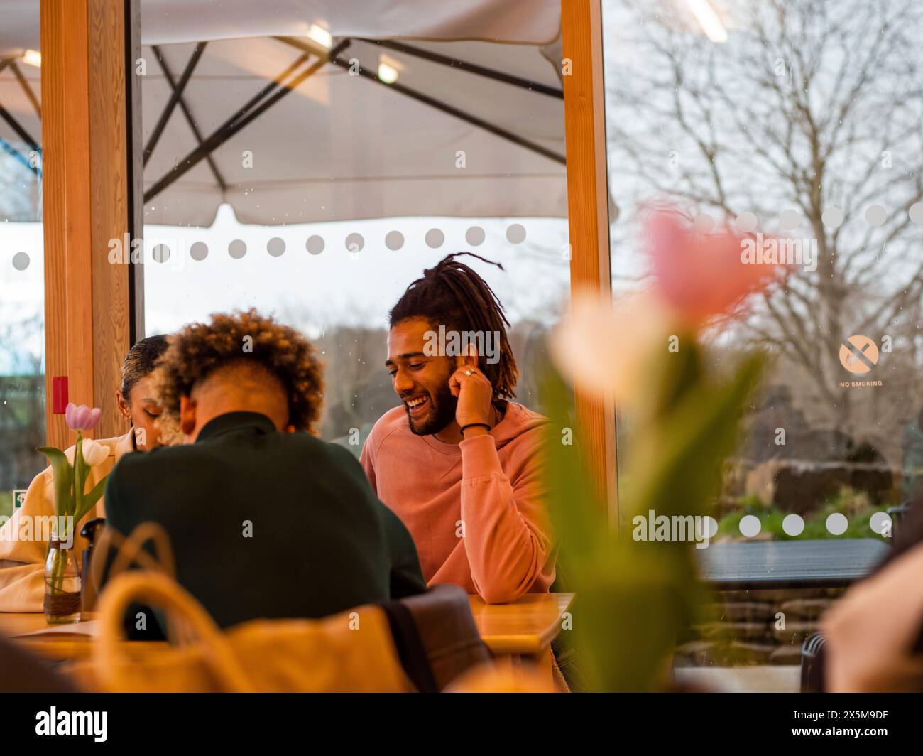Group of young friends sitting at restaurant table Stock Photo - Alamy
