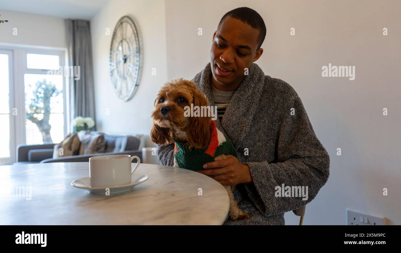 Man with dog on lap hi-res stock photography and images - Alamy