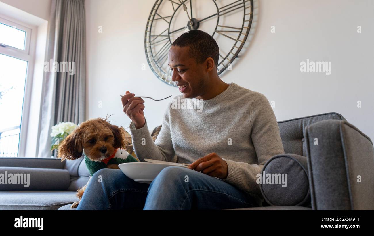 Man sitting on sofa eating hi-res stock photography and images - Alamy