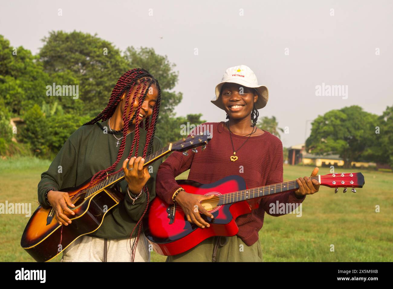 Two young women playing guitars Stock Photo - Alamy