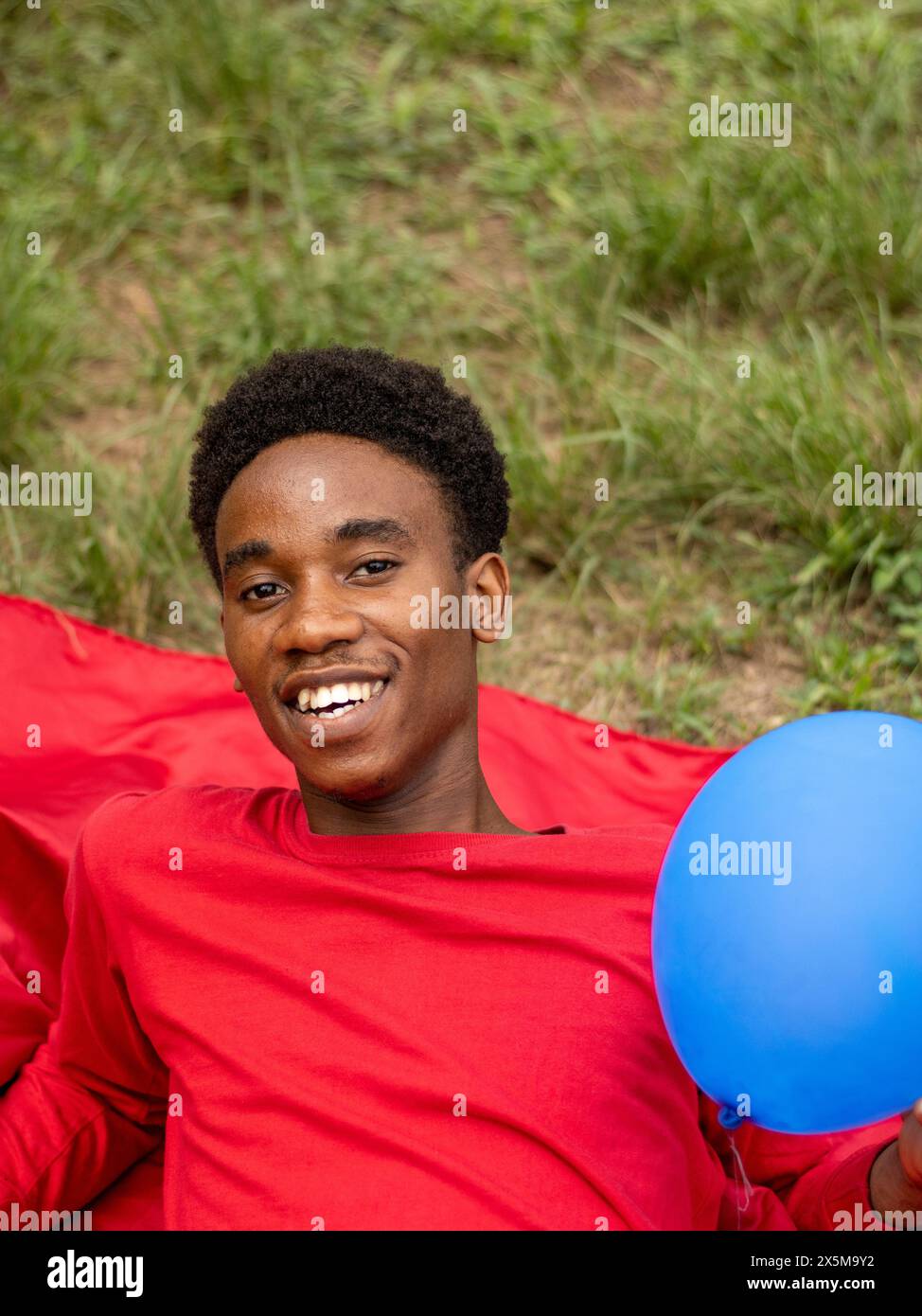 Portrait of young man holding balloon Stock Photo - Alamy