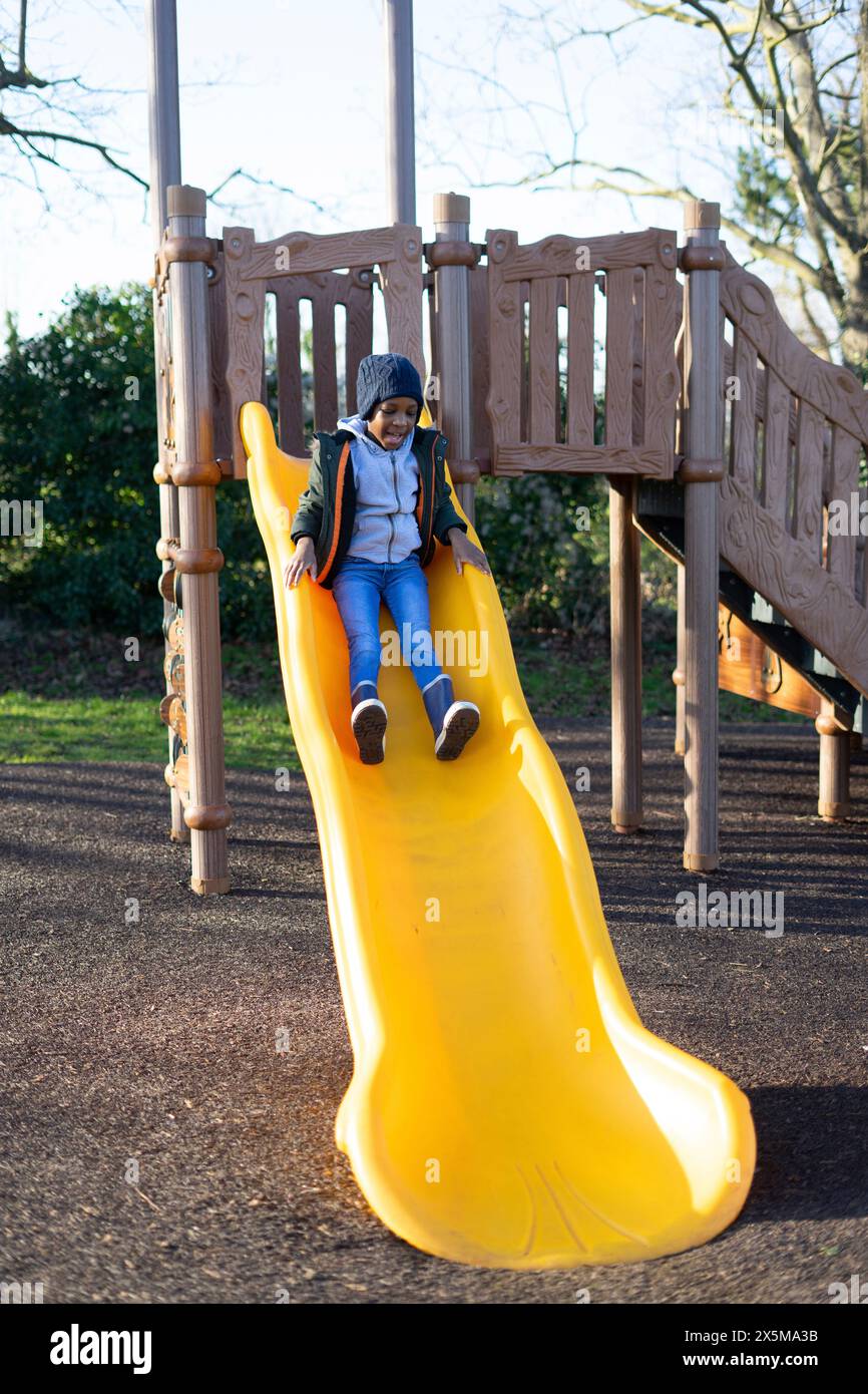 Boy on playground slide Stock Photo - Alamy