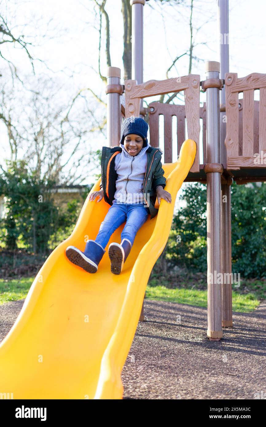 Boy on playground slide Stock Photo - Alamy