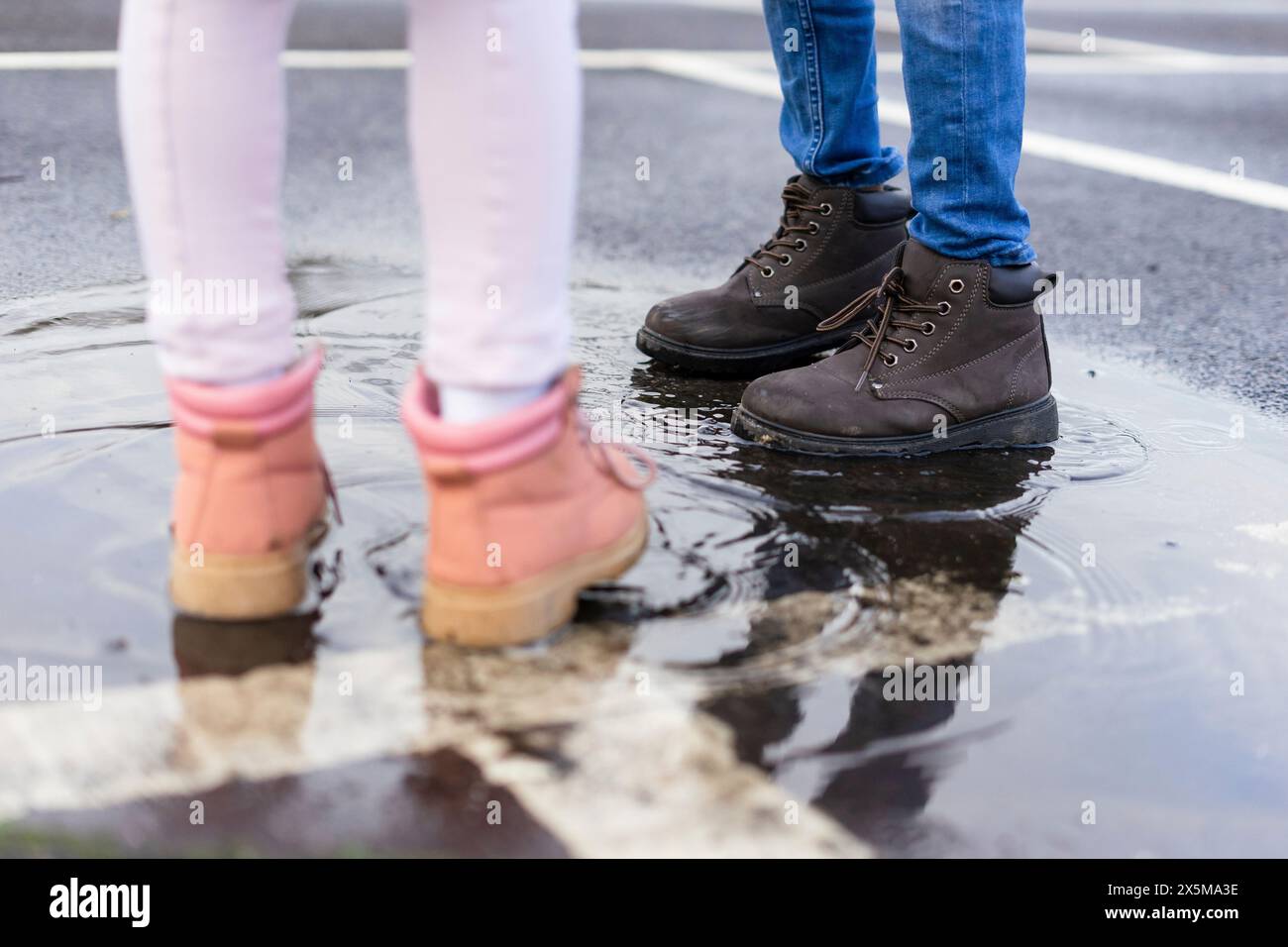 Girl and boy standing in puddle Stock Photo - Alamy