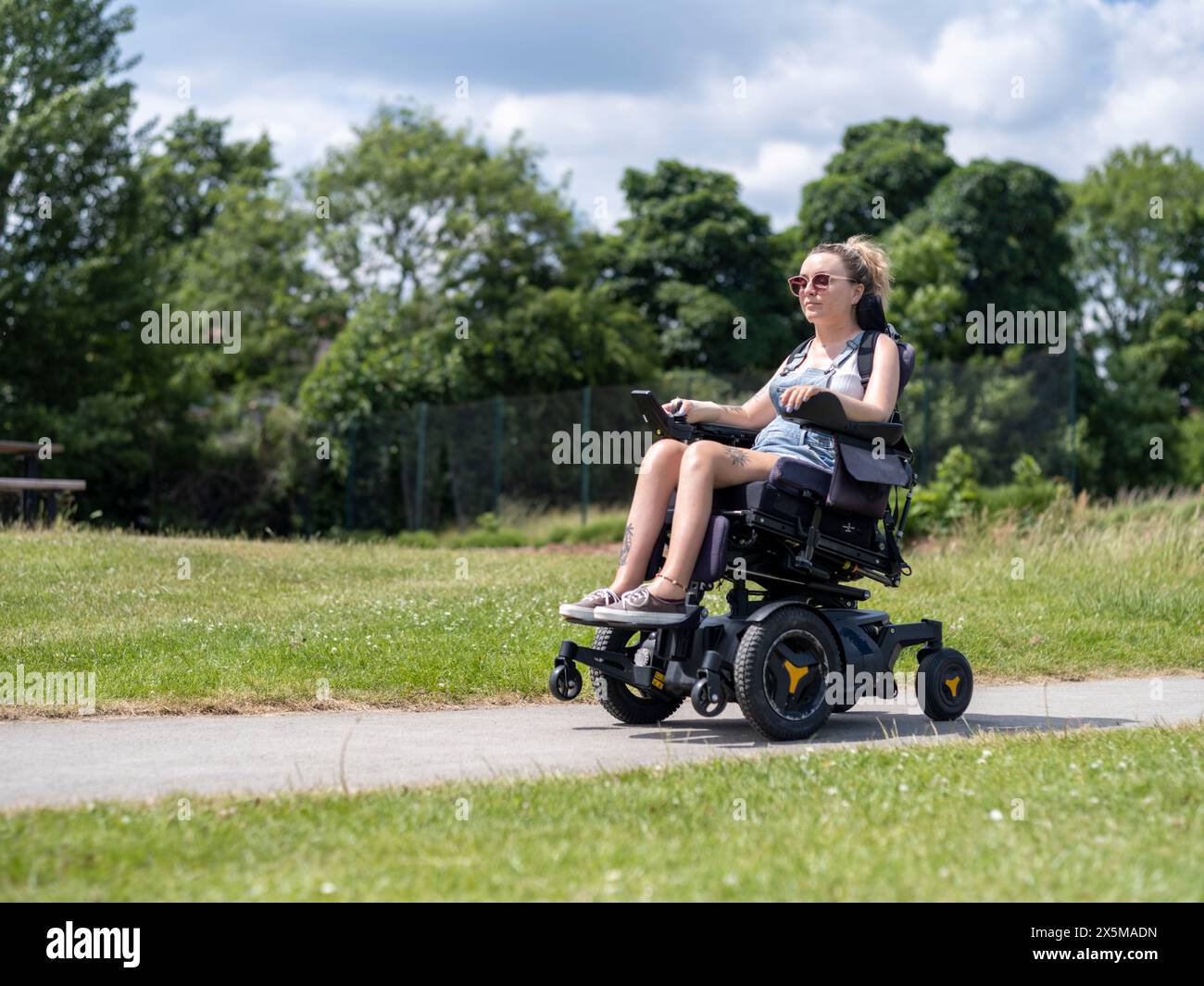 Woman in electric wheelchair going on walk Stock Photo - Alamy