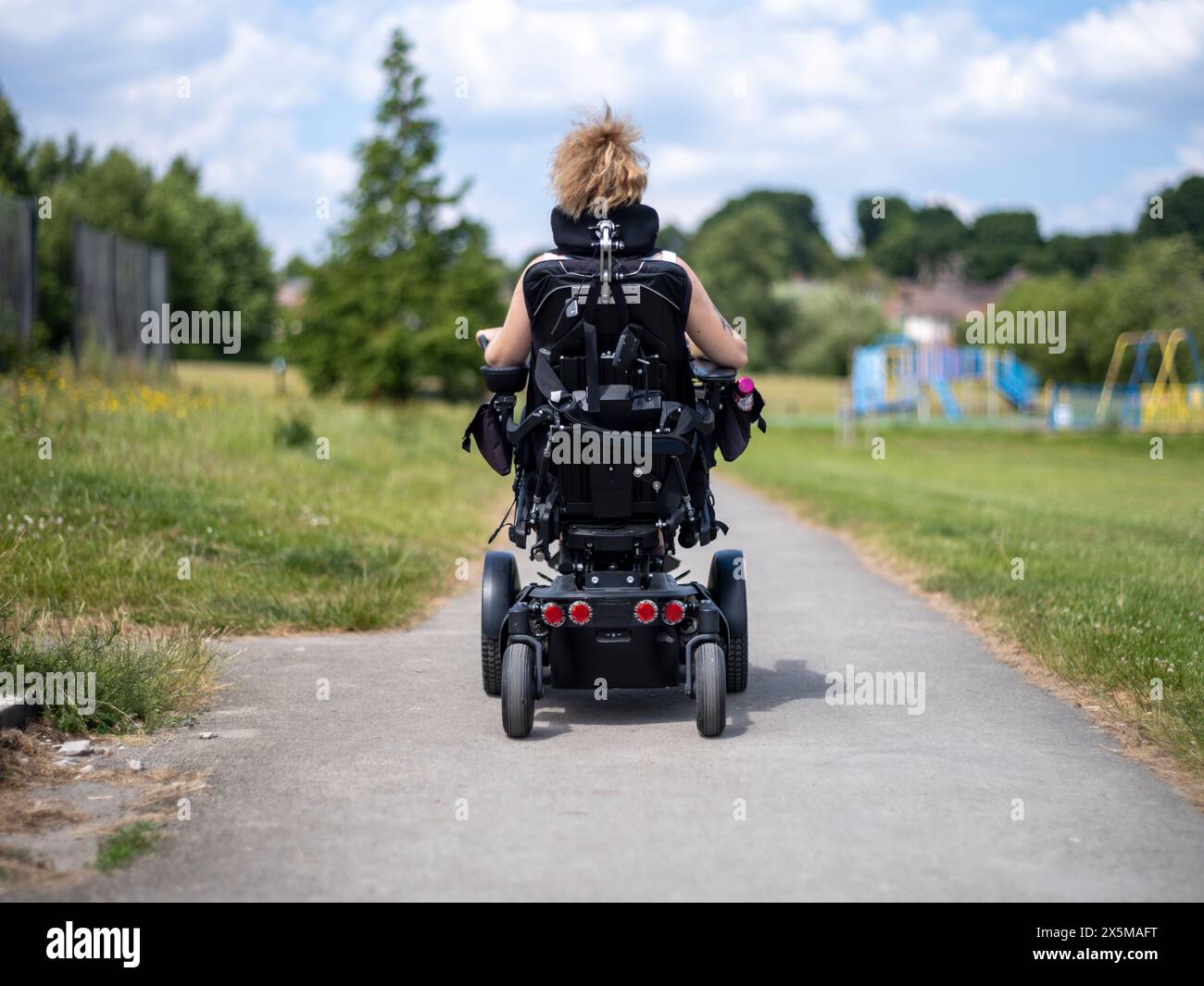 Woman in electric wheelchair going on walk Stock Photo - Alamy