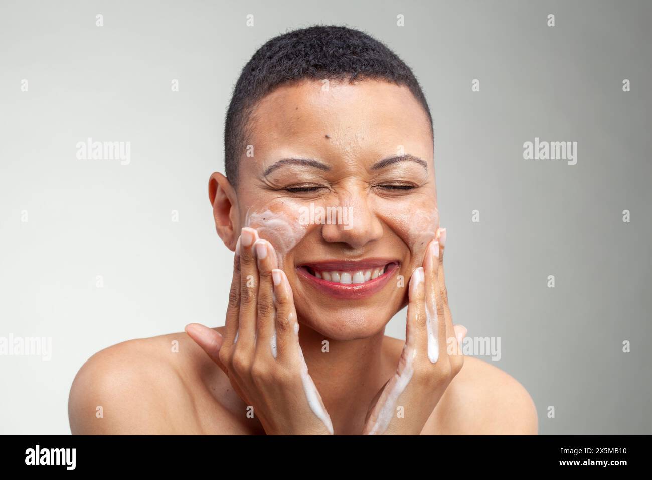 Portrait of smiling woman washing face Stock Photo - Alamy