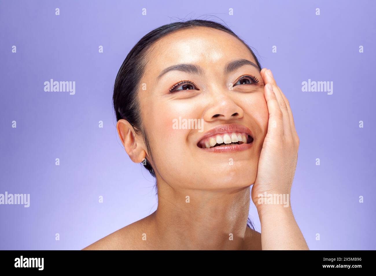 Studio portrait of smiling woman touching face Stock Photo - Alamy