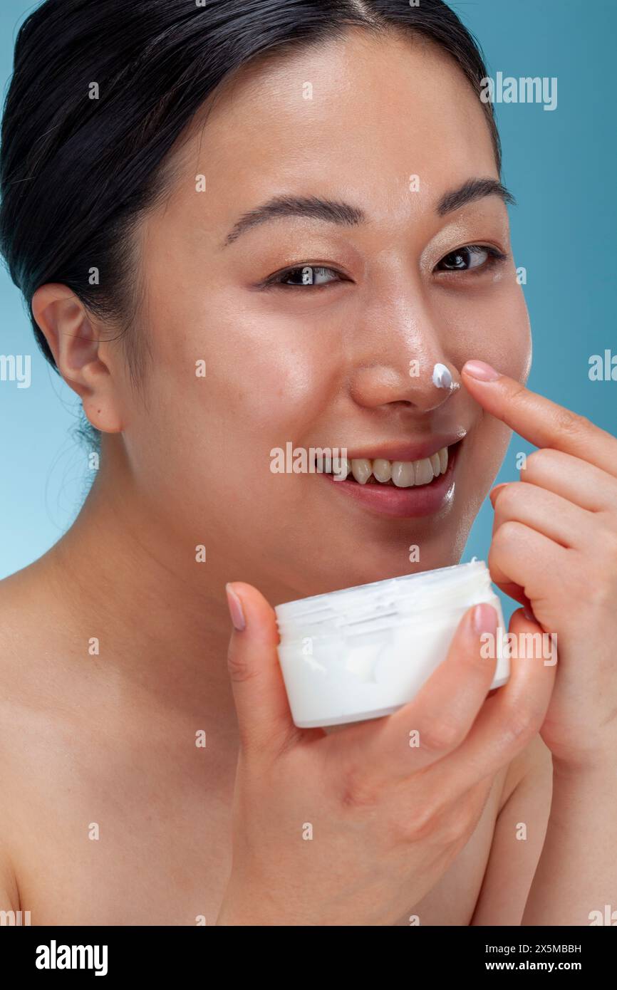Studio portrait of smiling woman with face cream Stock Photo - Alamy